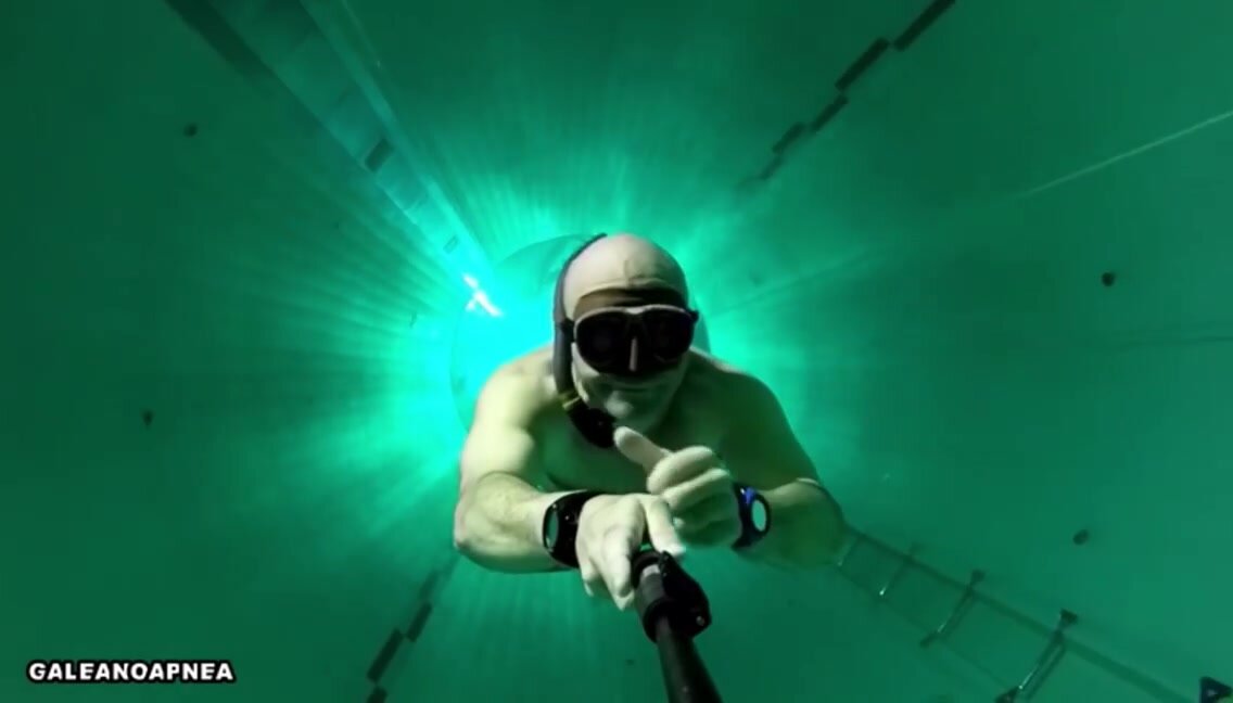 Bald Freediver Underwater In Blue Speedo